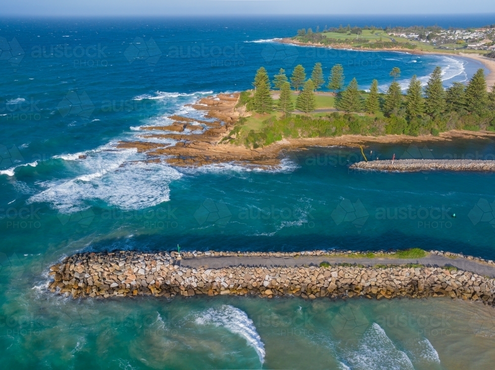 Image of Aerial view of a coastal river flowing out to sea between rock ...
