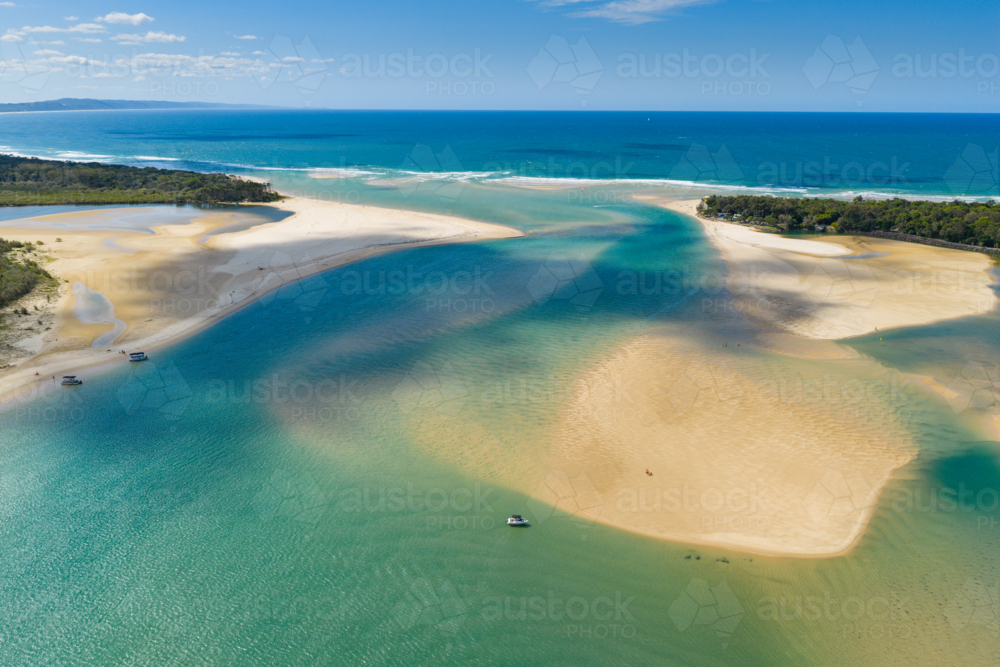 Image of Aerial view of a coastal river winding around sand bars and ...
