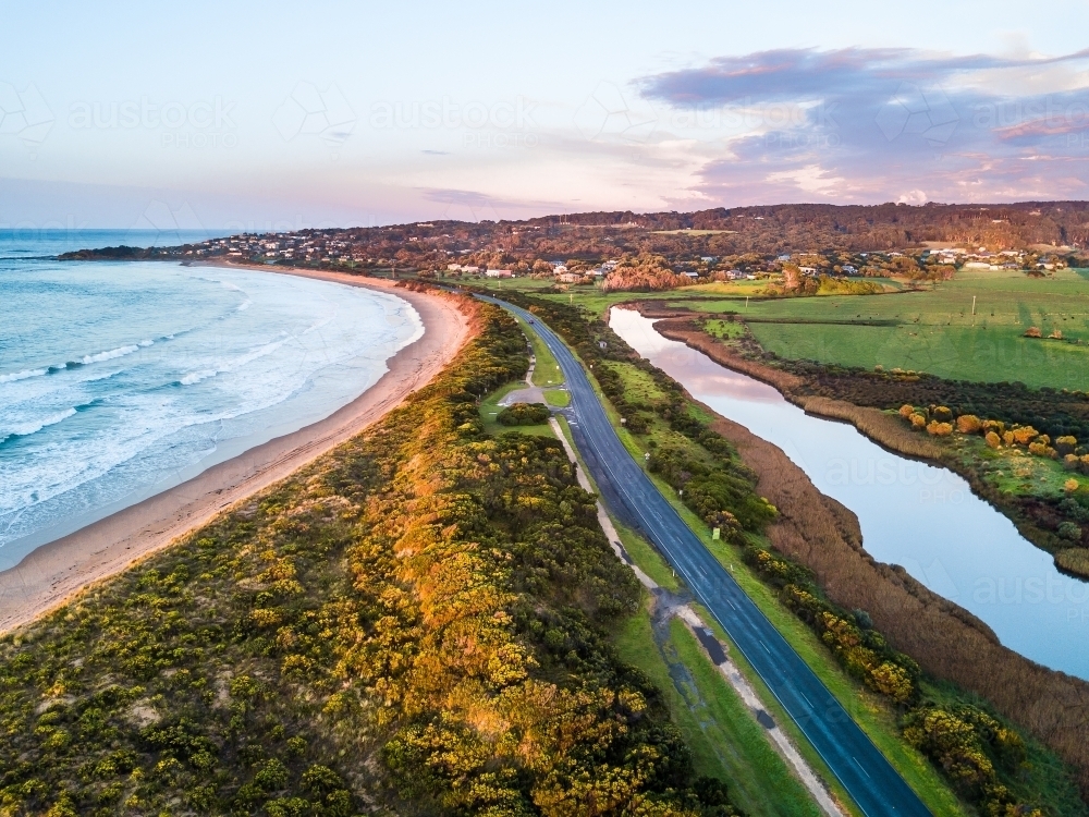 Image of Aerial view of a coastal road with a beach on one side and a ...