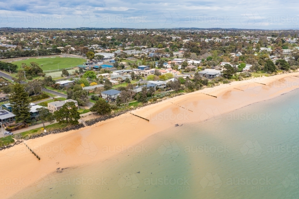 Image of Aerial view of a coastal town and golden sandy beach with ...