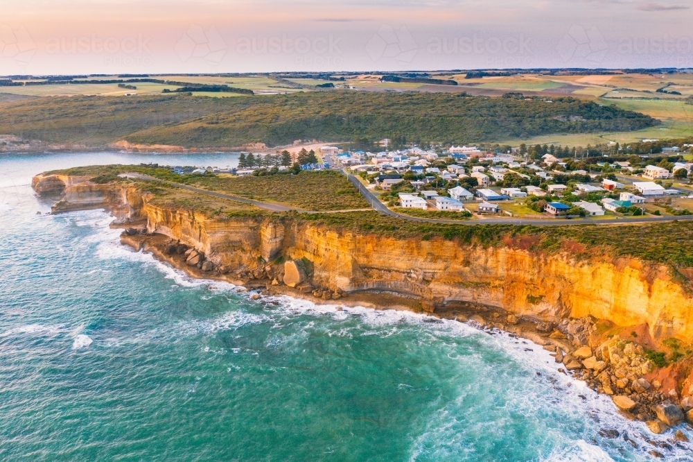 Image of Aerial view of a coastal town on sea cliffs above a rugged ...