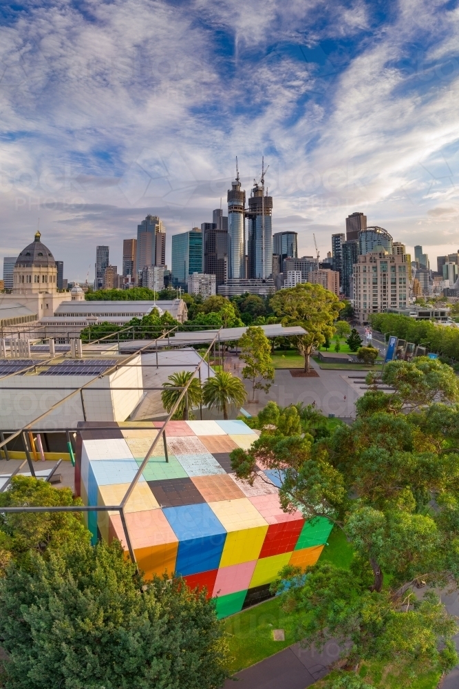 Image of aerial view of a colourful square building amongst trees in an ...
