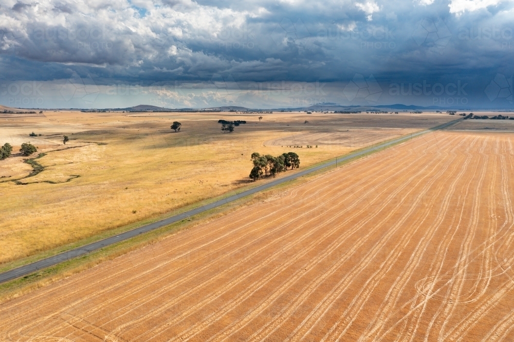 Image of Aerial view of a country road running though dry farm land ...