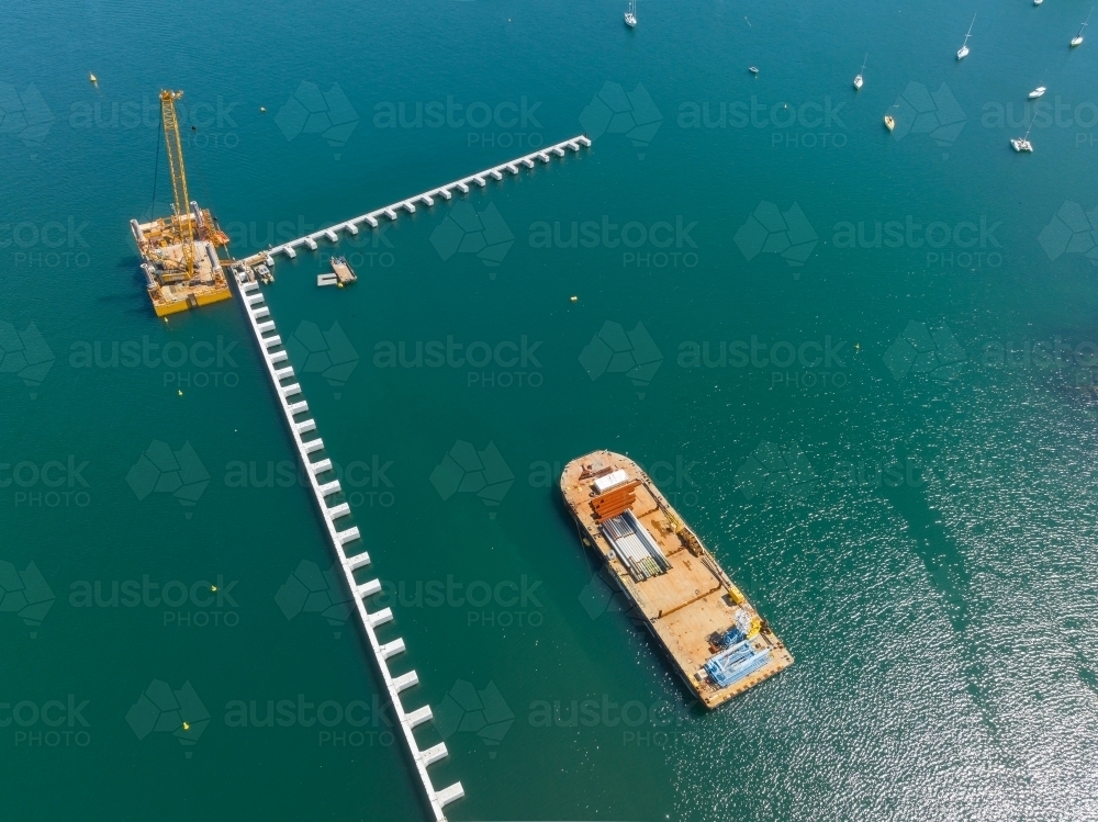 Image of Aerial view of a crane on a barge constructing a breakwater ...