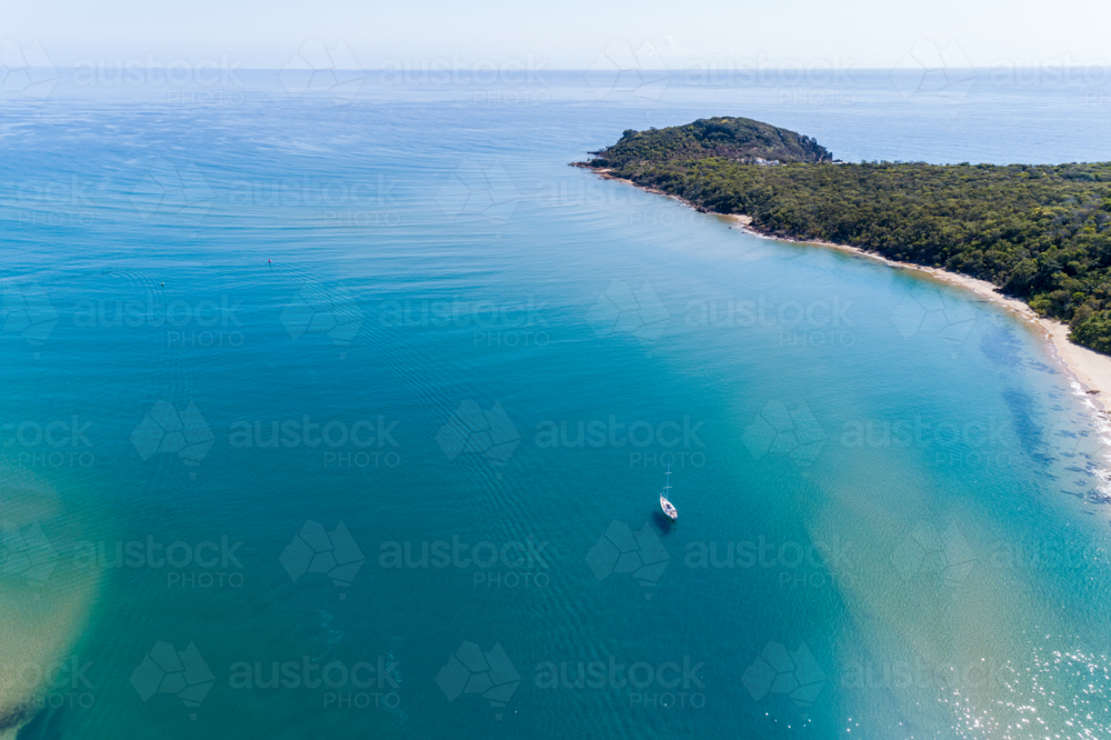 Image of Aerial view of a cruising sailboat yacht anchored in shallow ...