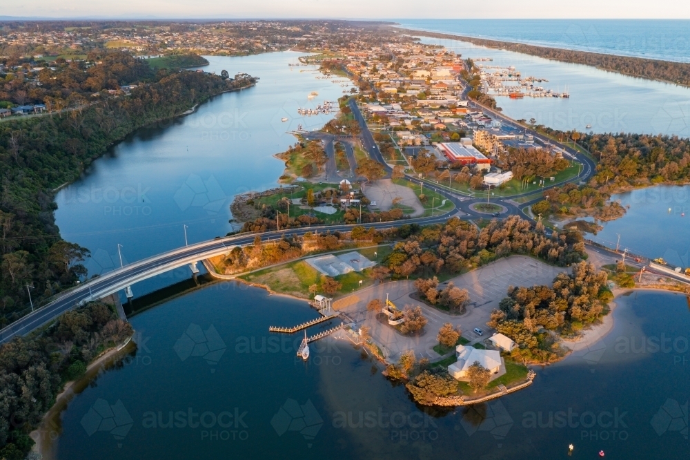 Image of Aerial view of a curved road bridge over a river joining a ...
