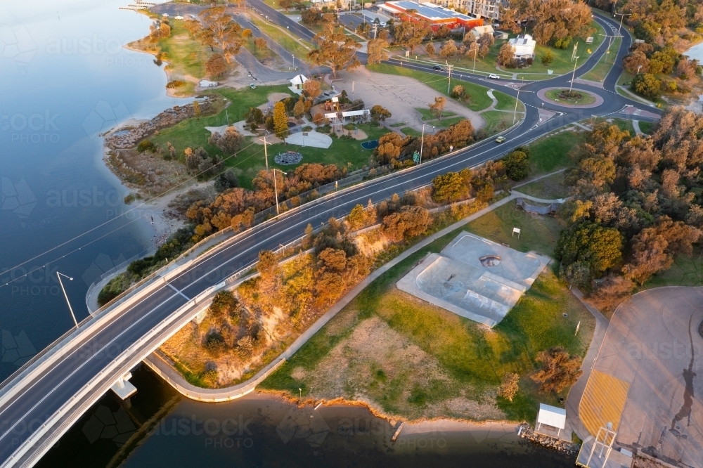 Image of Aerial view of a curved road bridge over a river running into ...