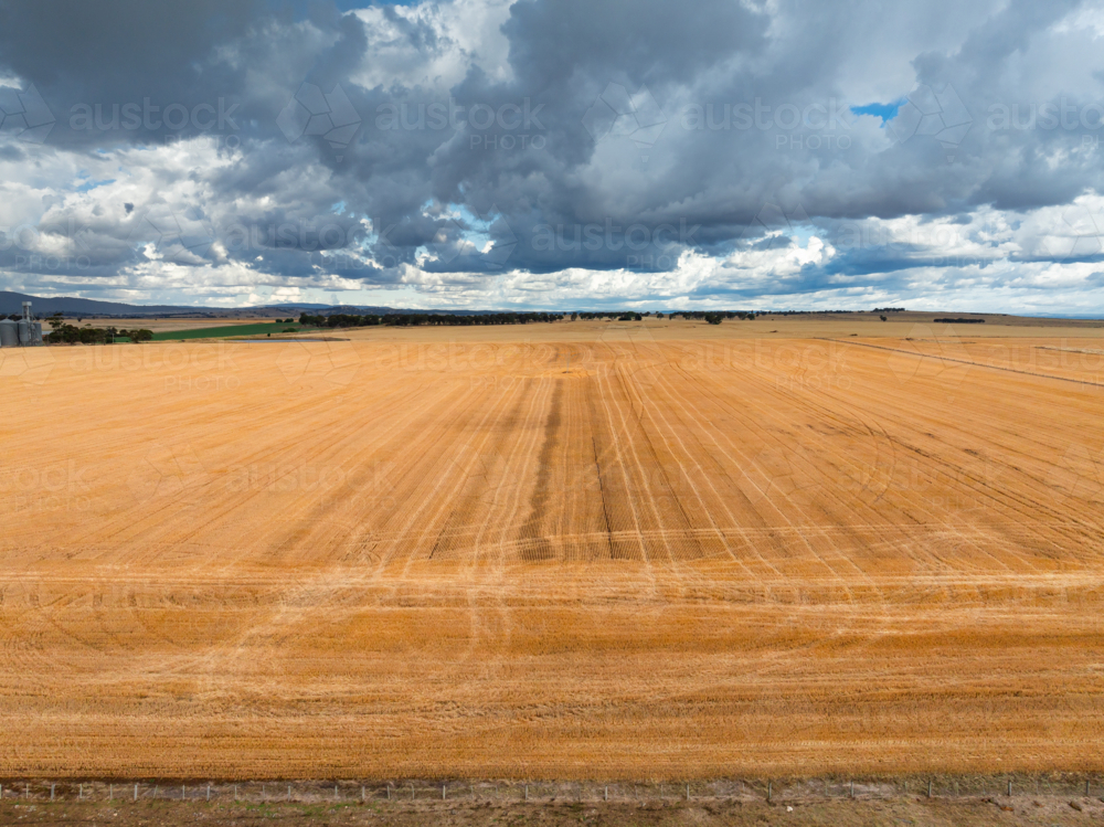 Image of Aerial view of a dark sky over a farm paddock with wheel ...