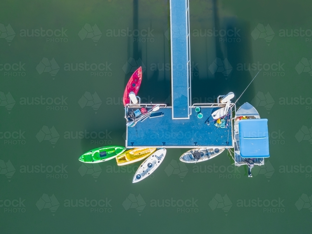 Image of Aerial view of a dinghy and brightly coloured kayaks tied to a ...