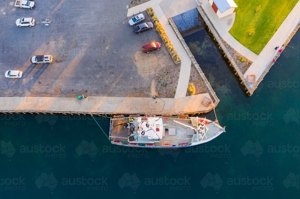 Image of Aerial view of a fishing trawler tied up at a dock near a slip ...