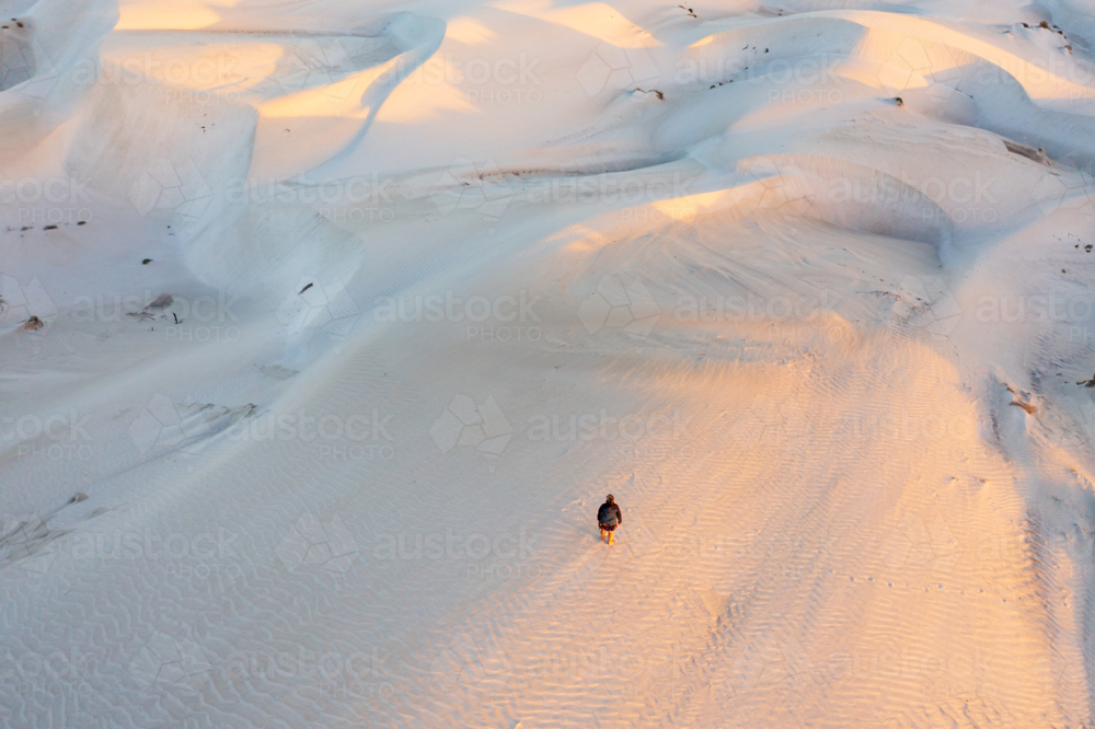 Image of Aerial view of a hiker exploring large white sand dunes at ...