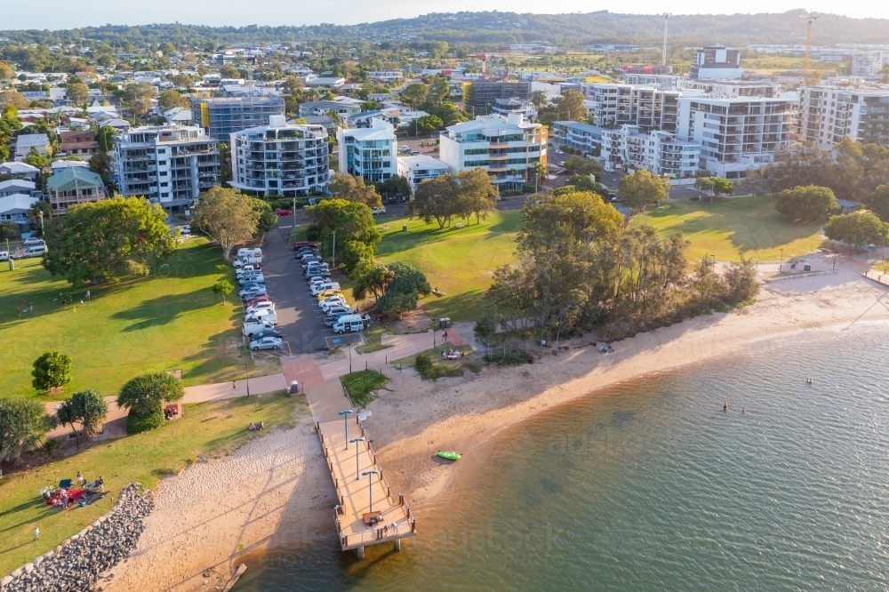 Image of Aerial view of a jetty over a beach in front of a coastal park ...