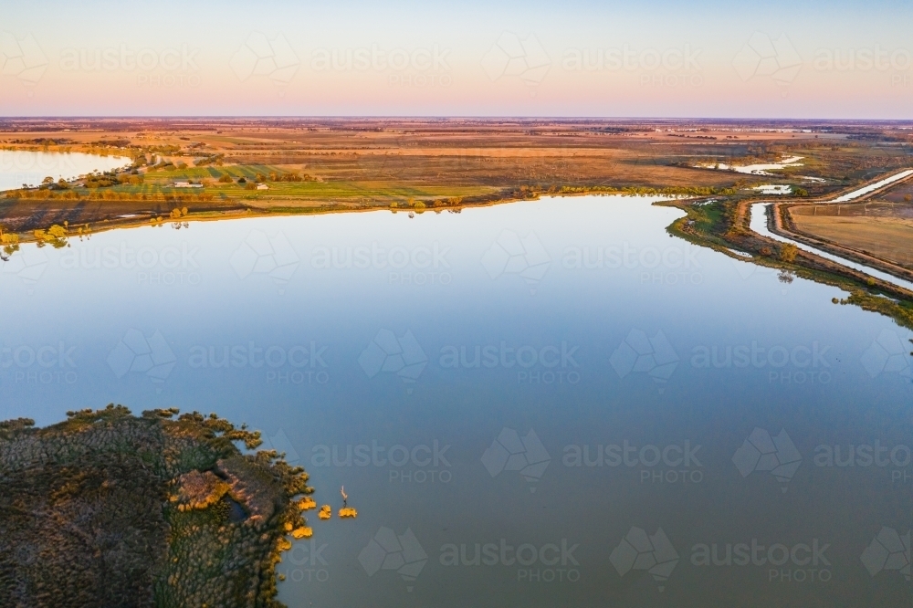 Image of Aerial view of a large calm inland lake at sunset - Austockphoto