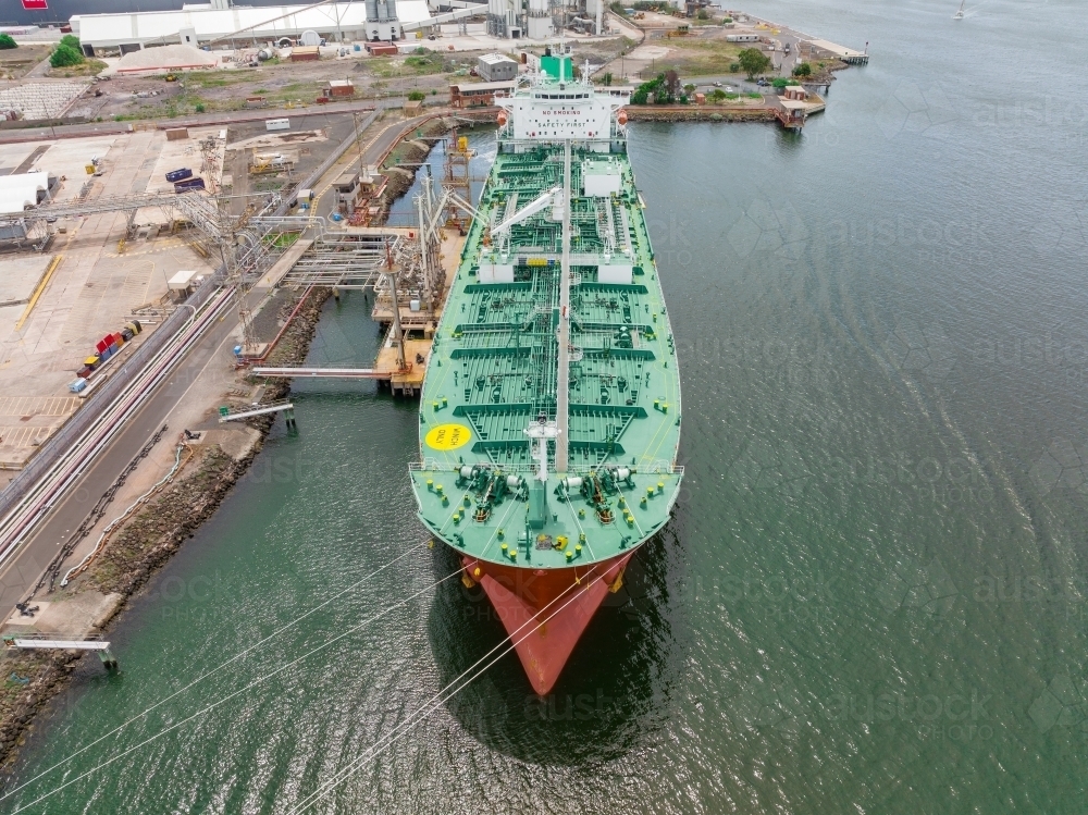 Image of Aerial view of a large tanker at port near storage tanks ...