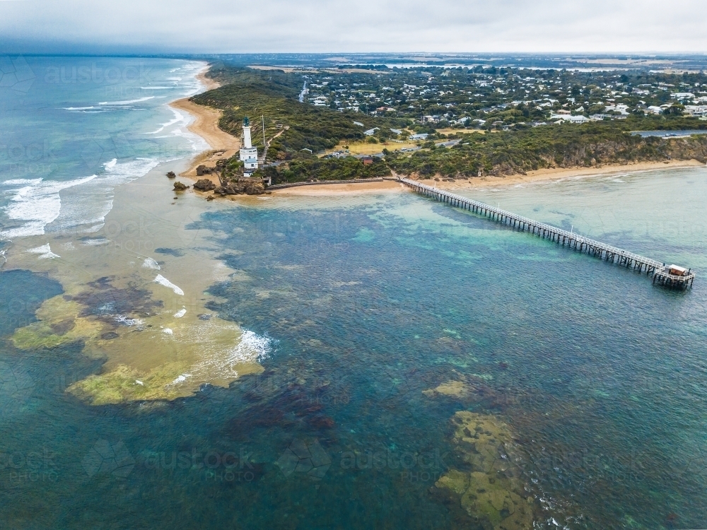 Image of Aerial view of a lighthouse and jetty jutting out into the ...