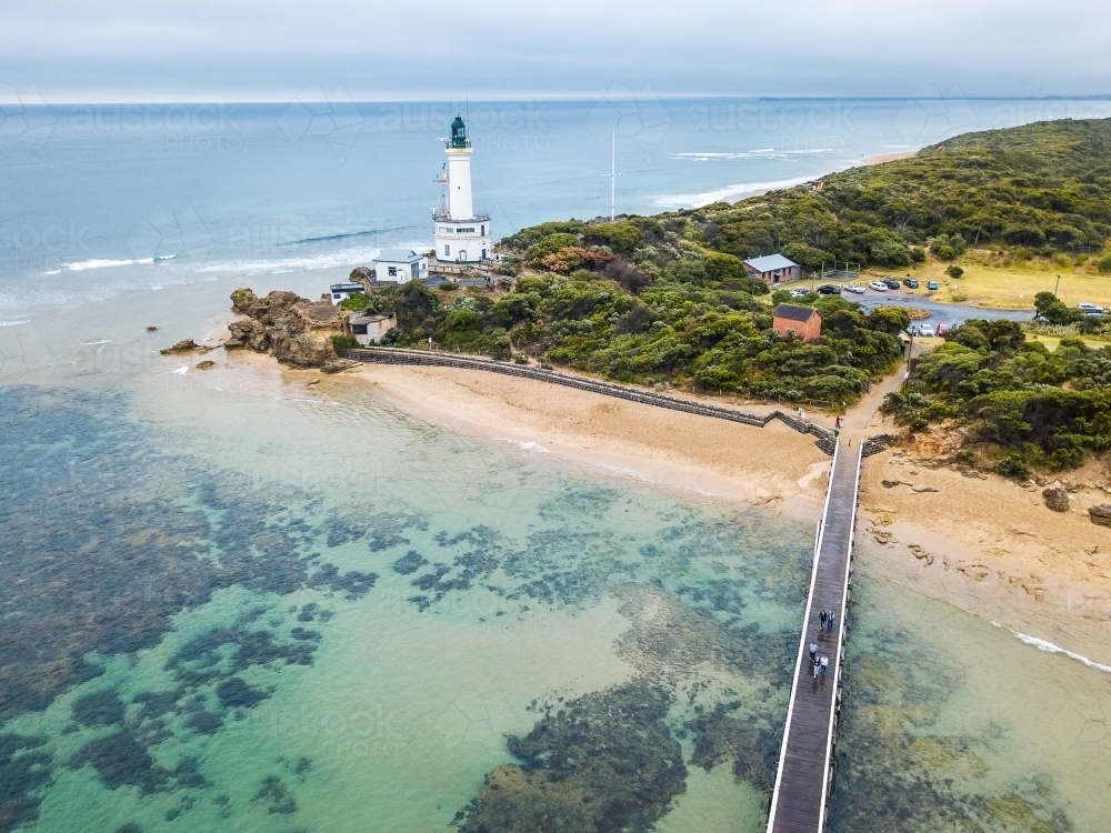 Image of Aerial view of a lighthouse and jetty jutting out into the ...