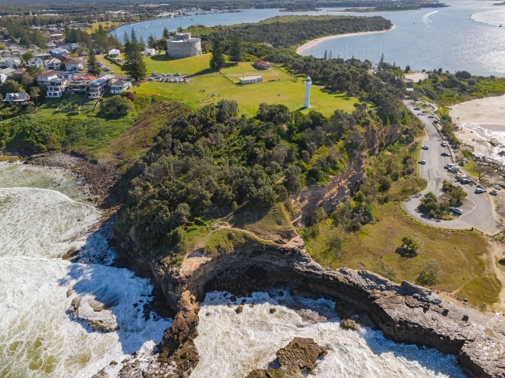 Image of Aerial view of a lighthouse on a green coastal reserve above ...