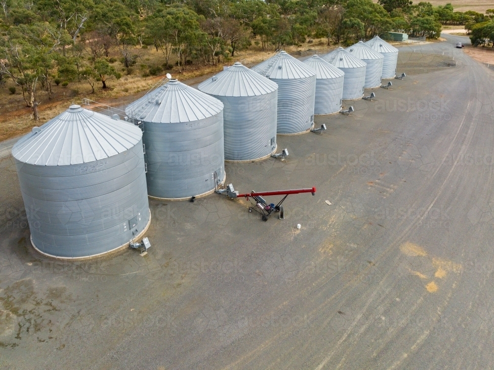Image of Aerial view of a line of grain storage bins and auger ...