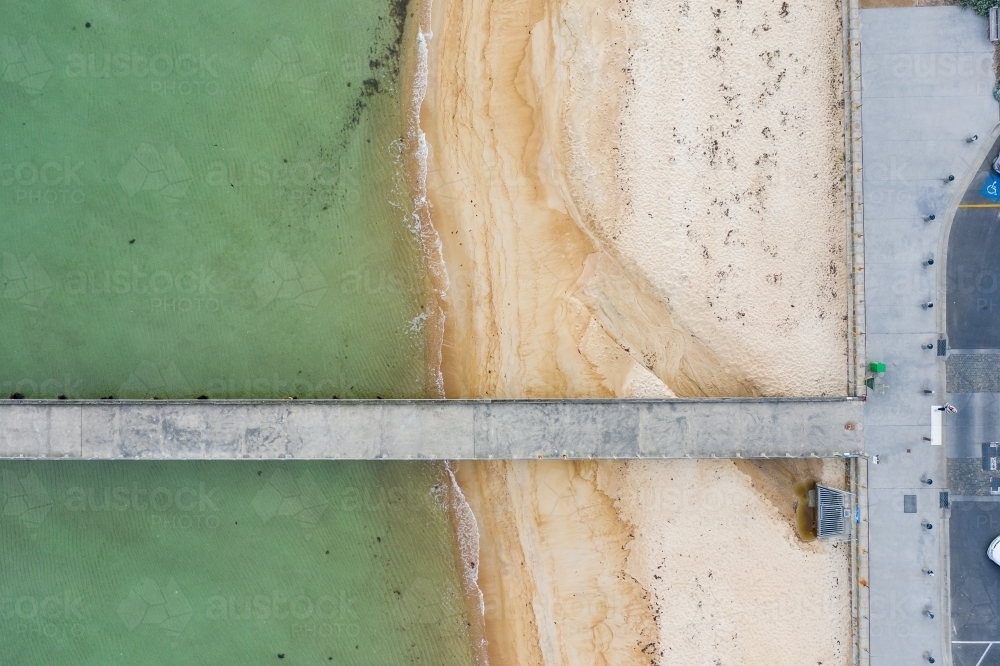 Image of Aerial view of a long narrow jetty over a beach and clam water ...
