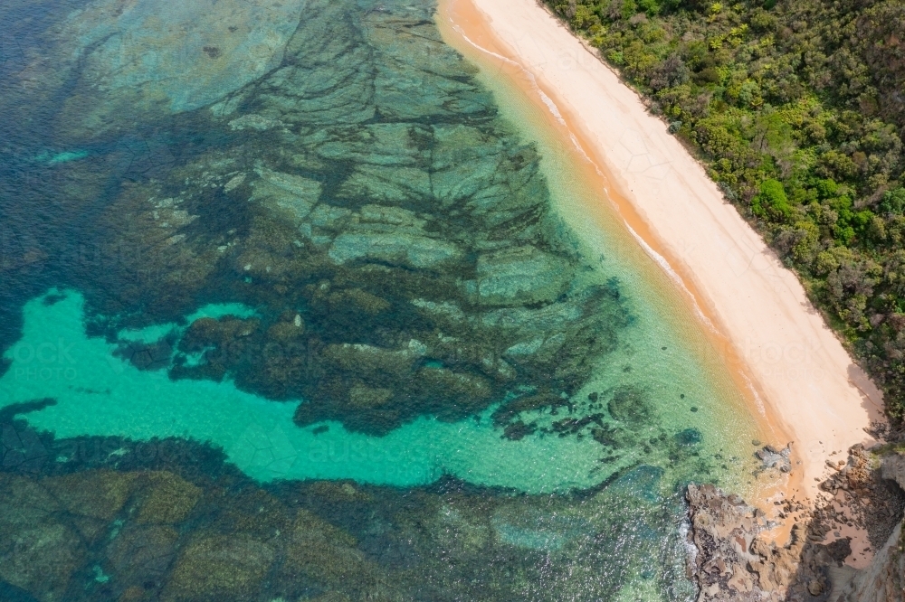 Image of Aerial view of a long sandy beach and rockpool patterns in a ...