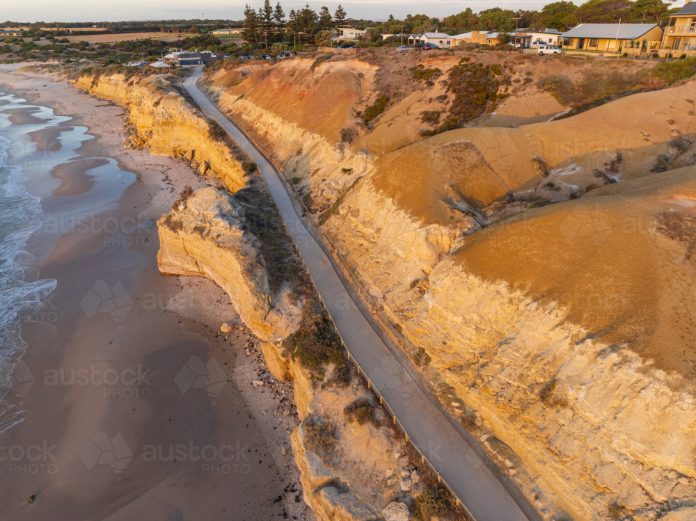 Image of Aerial view of a long sloping track down an eroded cliff face ...