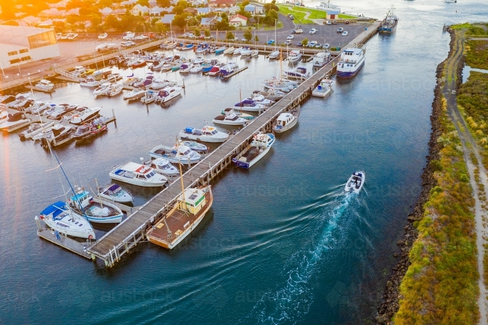 Image of Aerial view of a marina at sunset with a small runabout ...