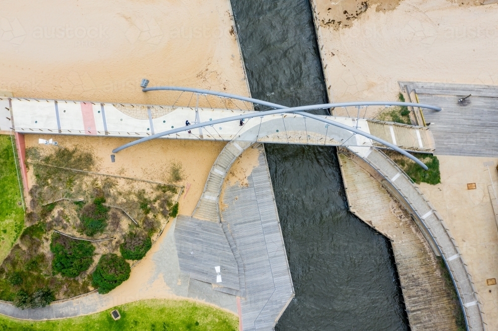 Image of Aerial view of a modern arched walking bridge over a marina ...