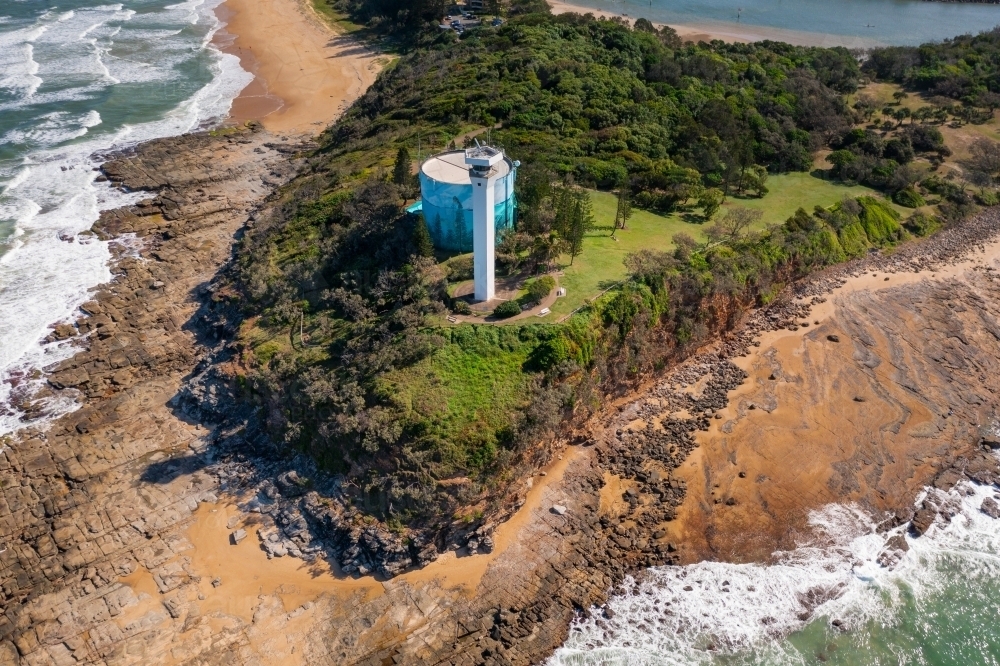 Image of Aerial view of a modern lighthouse on a clifftop next to a ...