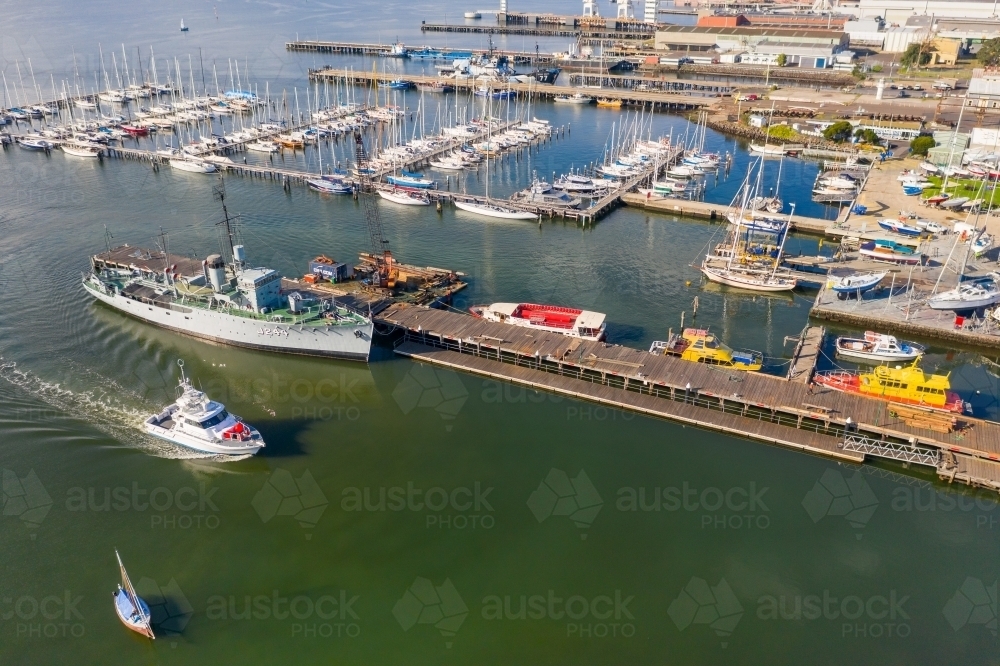 Image of Aerial view of a naval ship at a dock at a bay side harbour ...