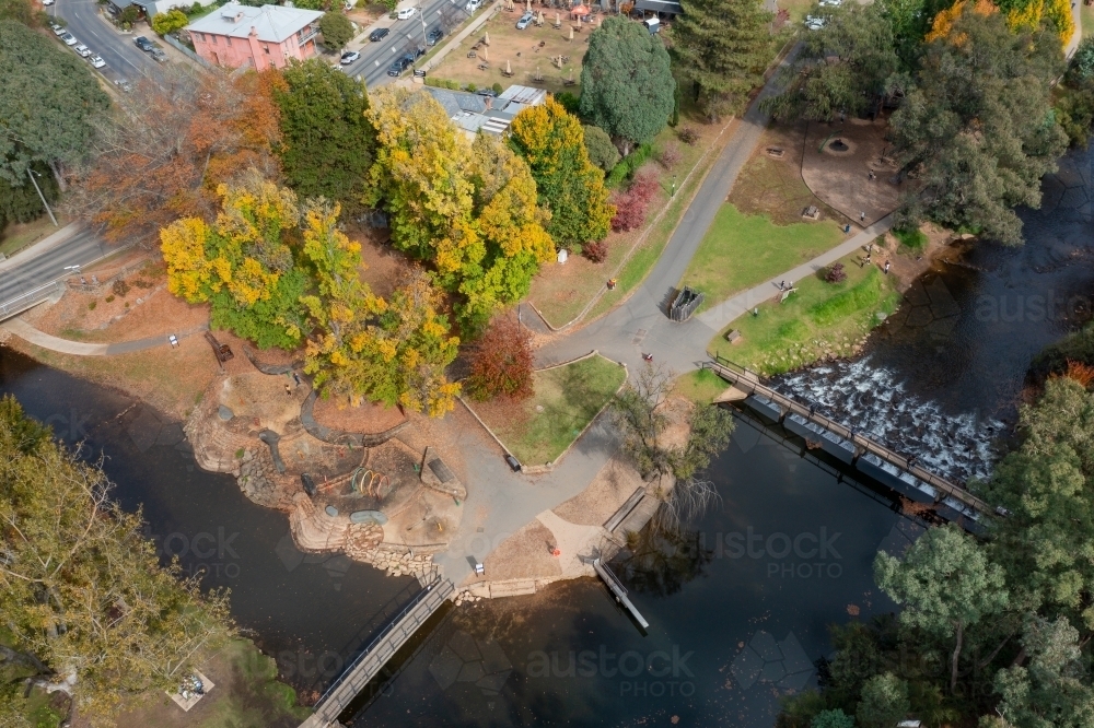 Image of Aerial view of a park full of autumn coloured trees along side ...