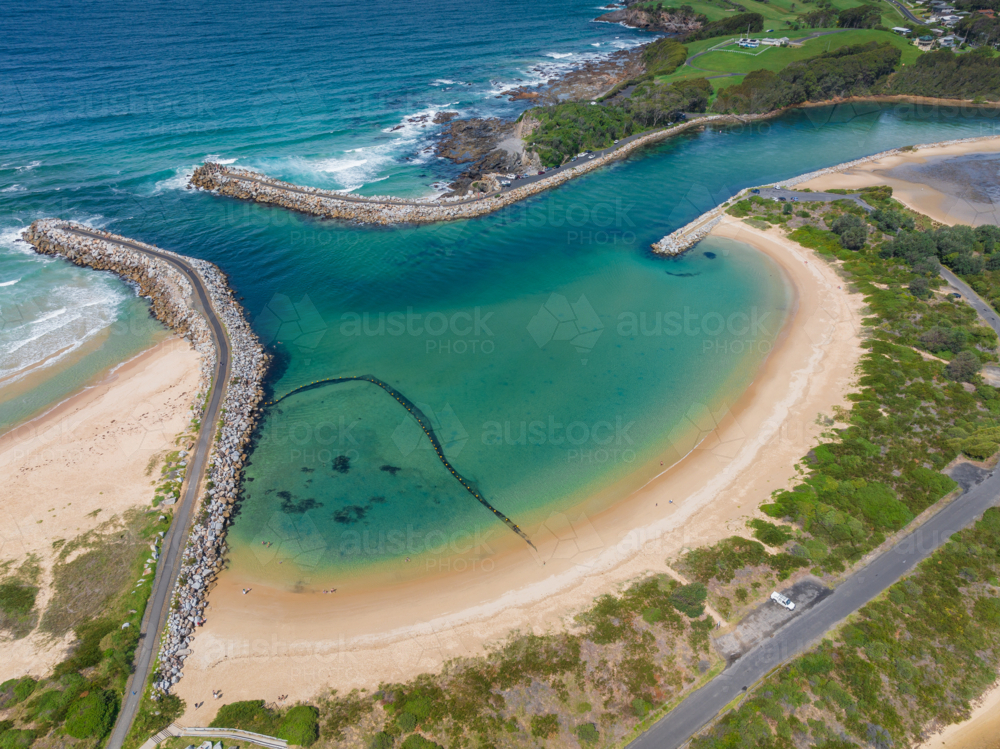 Image of Aerial view of a pristine curved beach behind a coastal inlet ...