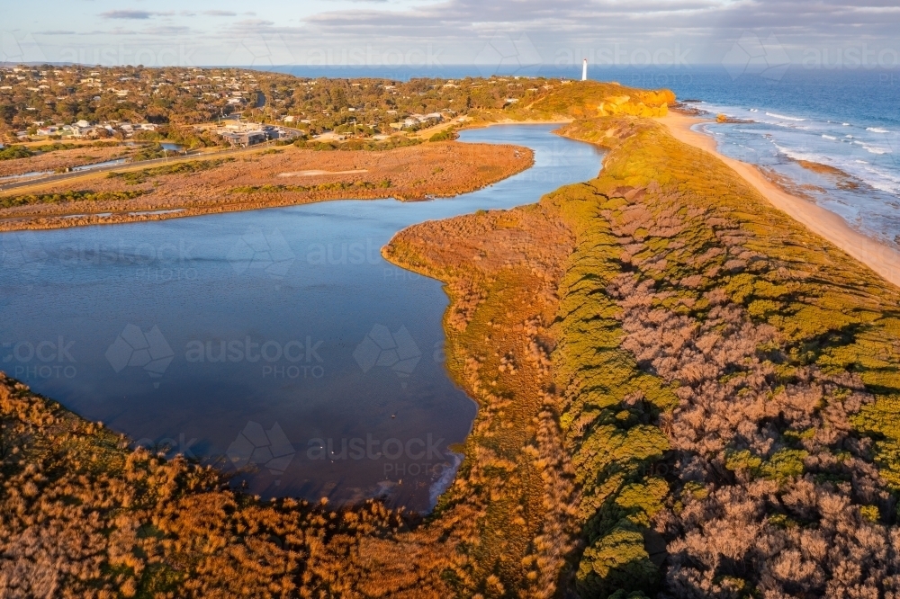 Image of Aerial view of a river flowing along a coastal headland and ...
