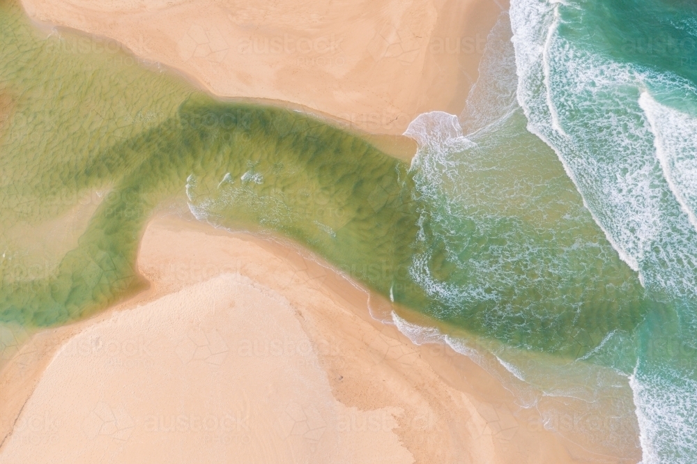 Image of Aerial view of a river winding its way over a sandy beach and ...