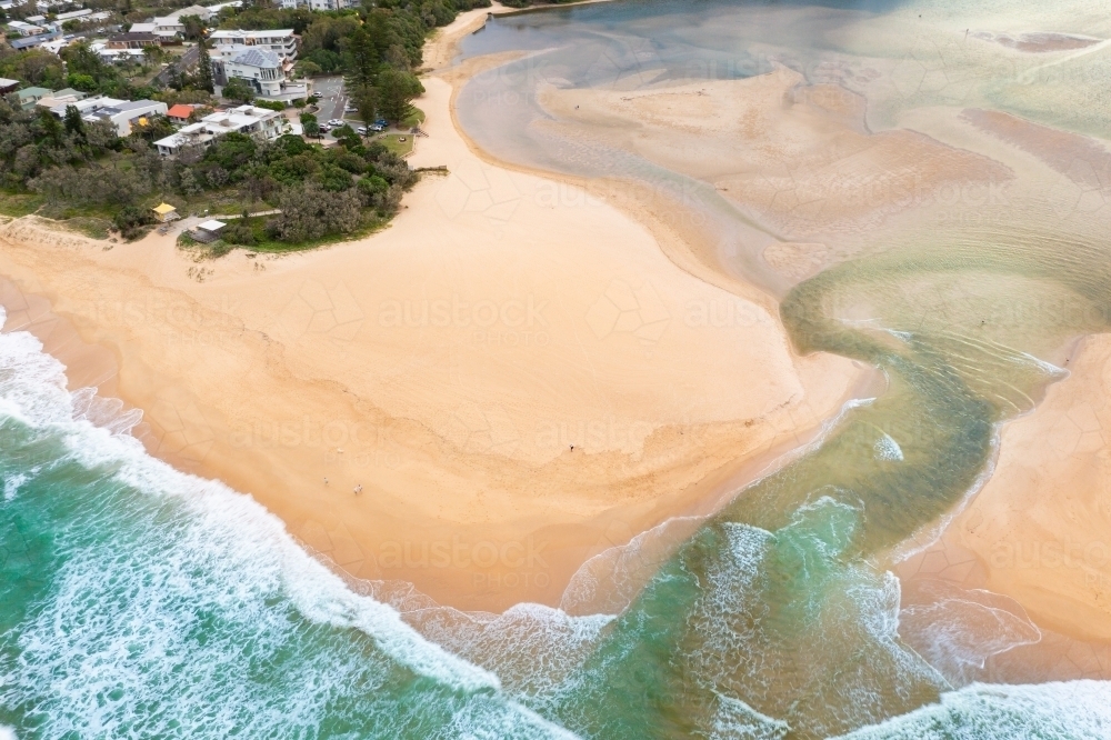 Image of Aerial view of a river winding its way over a sandy beach and ...