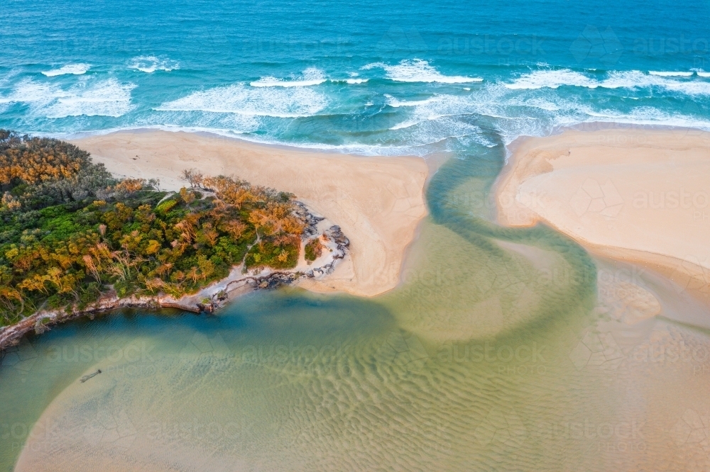Image of Aerial view of a river winding its way over a sandy beach and ...