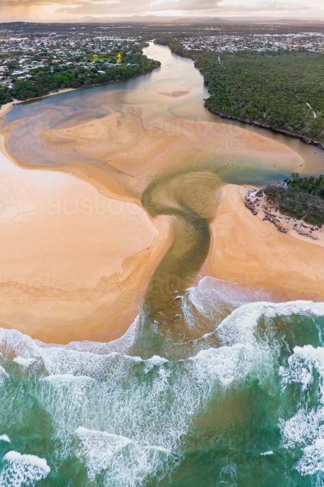 Image of Aerial view of a river winding its way over a sandy beach and ...