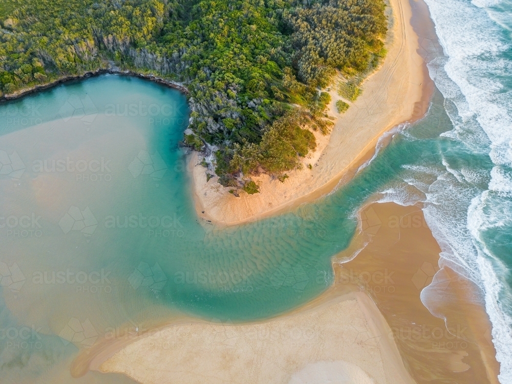 Image of Aerial view of a river winding through a beach and out to sea ...
