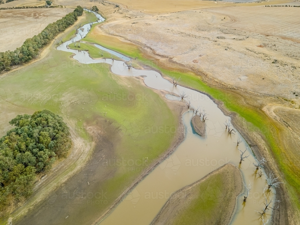 Image of Aerial view of a river winding through farmland - Austockphoto