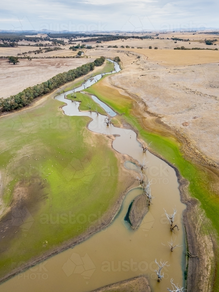 Image of Aerial view of a river winding through farmland - Austockphoto