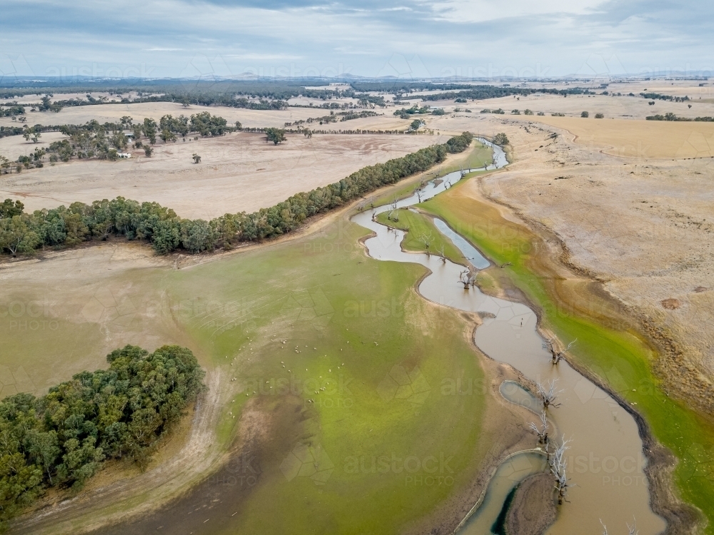 Image of Aerial view of a river winding through farmland - Austockphoto