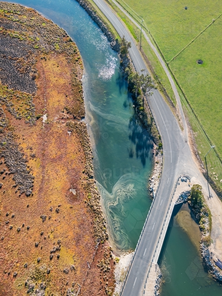 Image of Aerial view of a road alongside a river and crossing over a ...