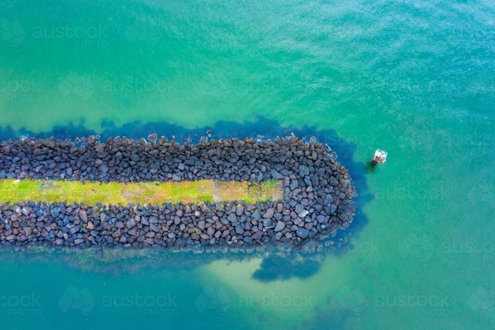 Image of Aerial view of a rocky breakwater surrounded deep blue water ...