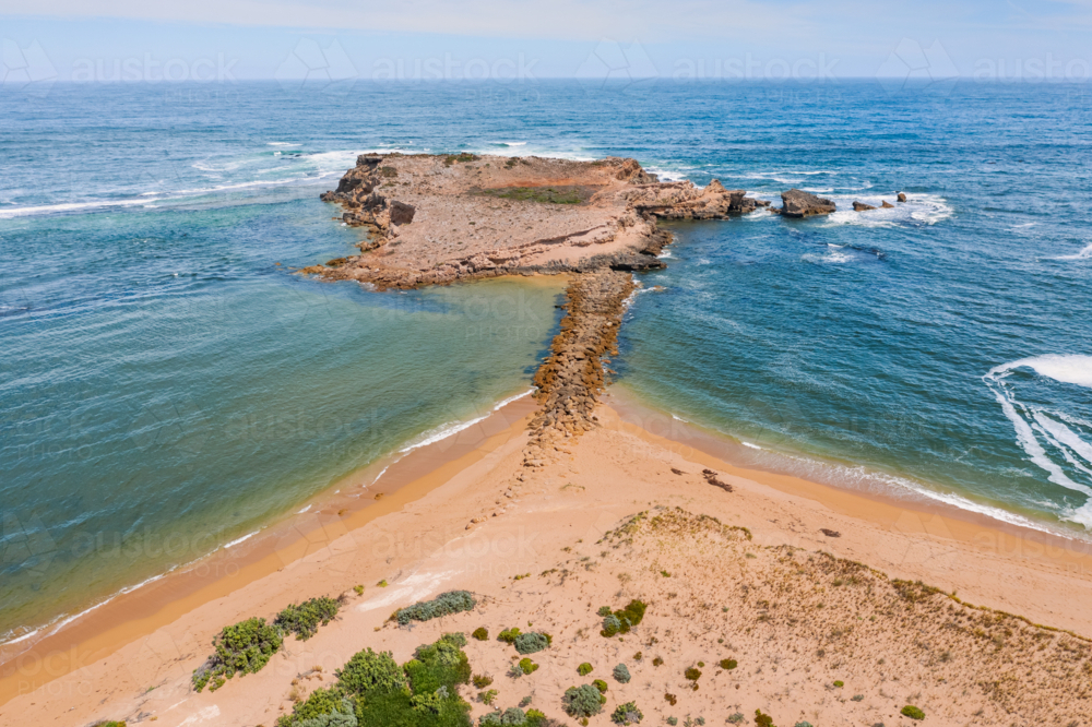 Image of Aerial view of a rocky island connected to a beach with a rock ...