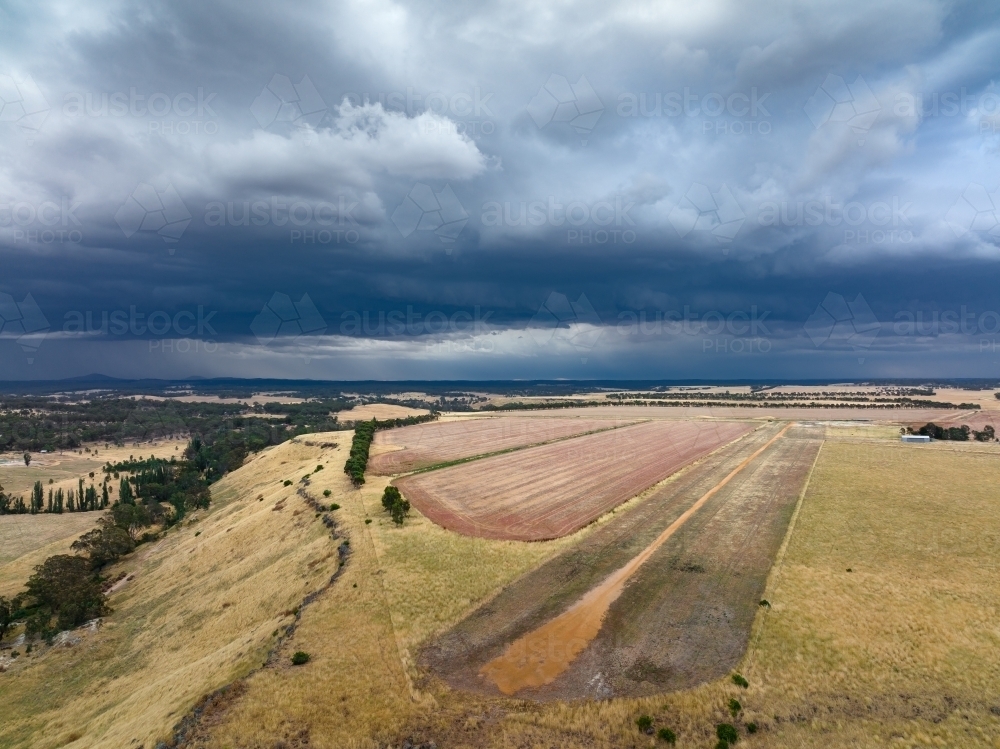 Image of Aerial view of a rural airstrip under heavy dark clouds ...
