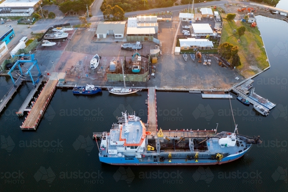 Image of Aerial view of a ship at a wharf alongside a ship repair dock ...