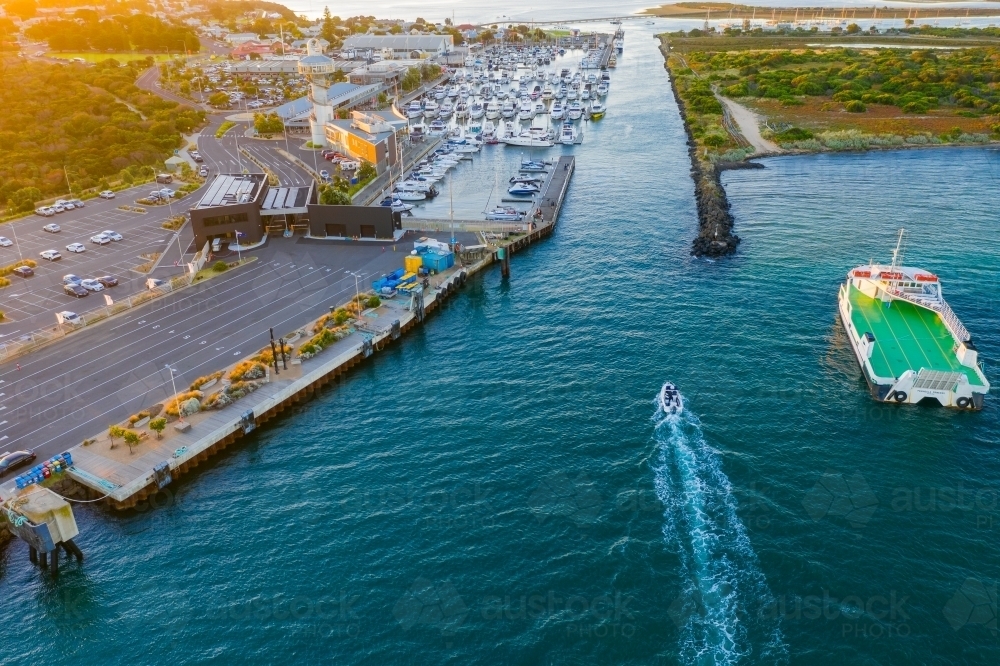 Image of Aerial view of a small power boat heading toward a marina past ...