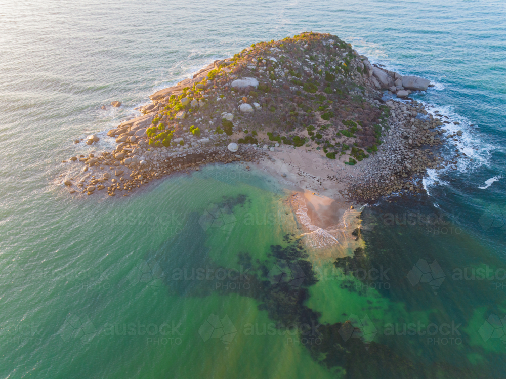 Image of Aerial view of a small rocky island in a clam ocean bay ...