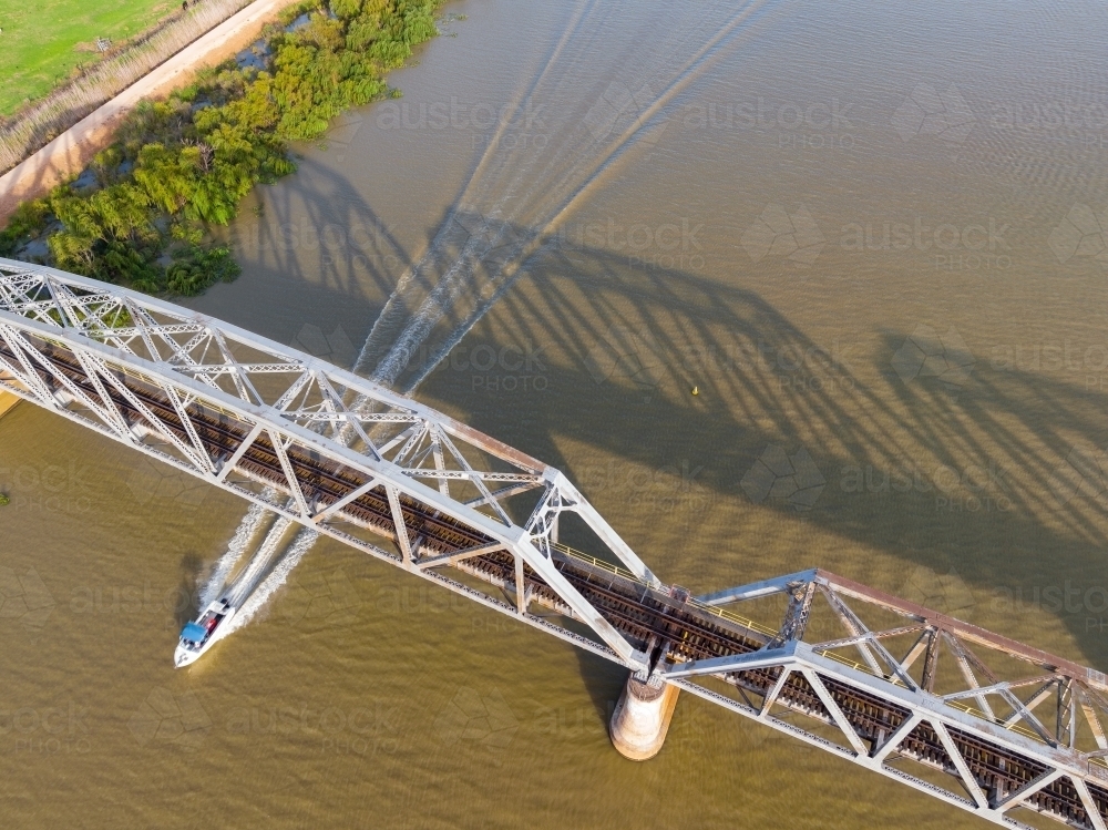 Image of Aerial view of a speed boat going under a steel bridge ...