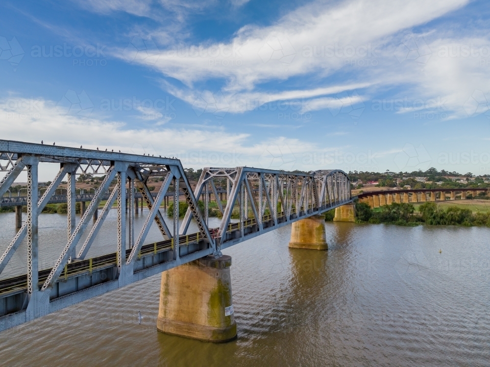 Image of Aerial view of a steel bridge crossing a wide brown river ...