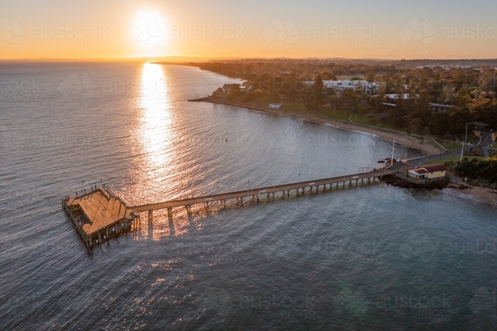 Image of Aerial view of a sunrise over a long straight jetty leading ...